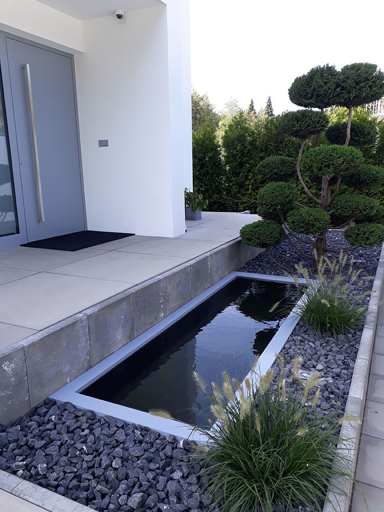 Rechteckiges Wasserbecken mit Edelstahlrand und kleinem Wasserspiel ...