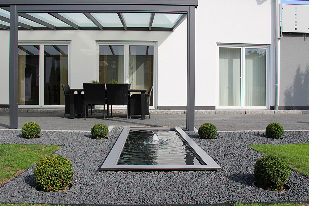 Formales Wasserbecken mit Wasserfontäne an der Terrasse - Gartenbrunnen ...